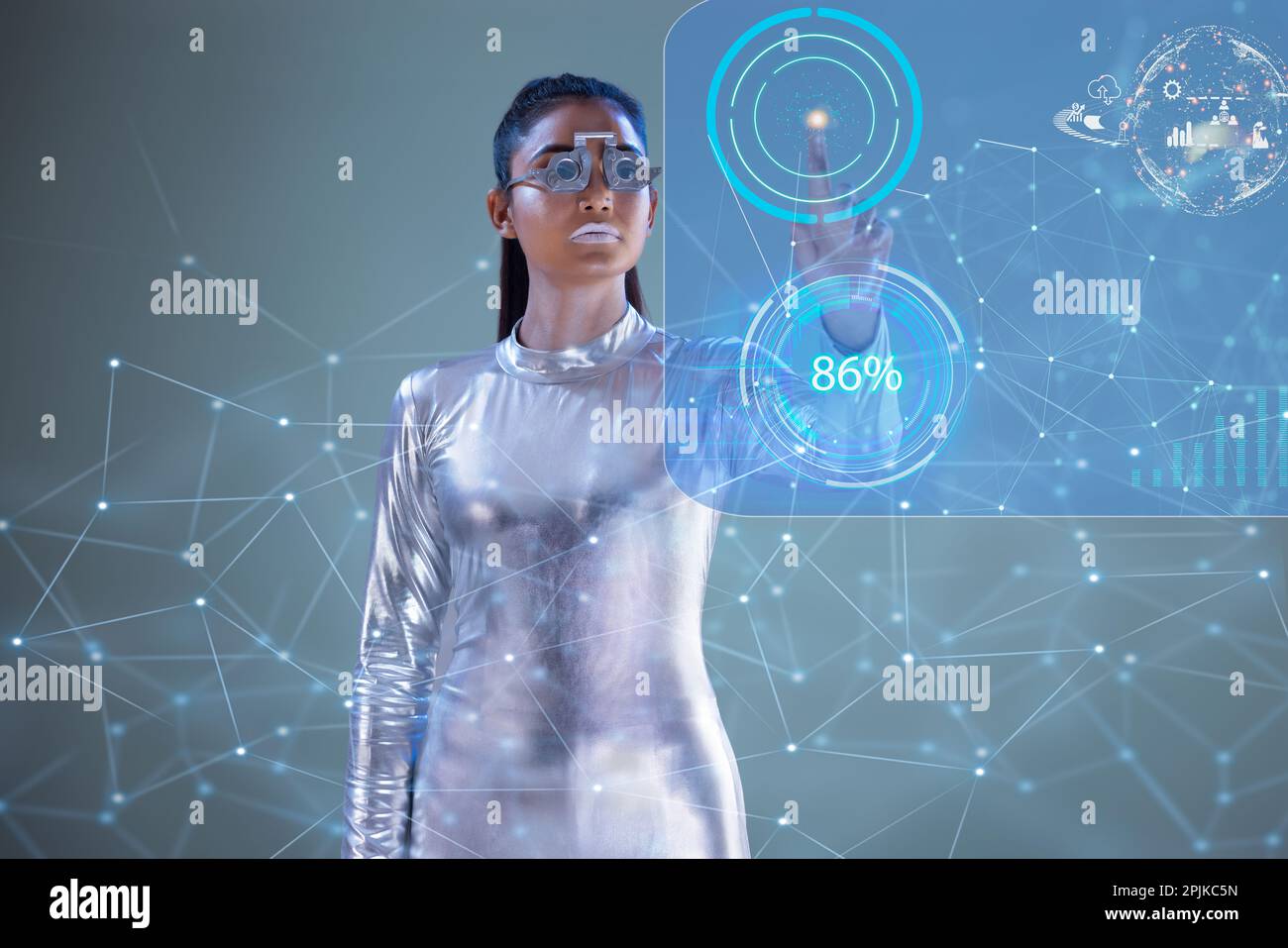 A woman wearing silver dress touching a digital Screen standing on a ...