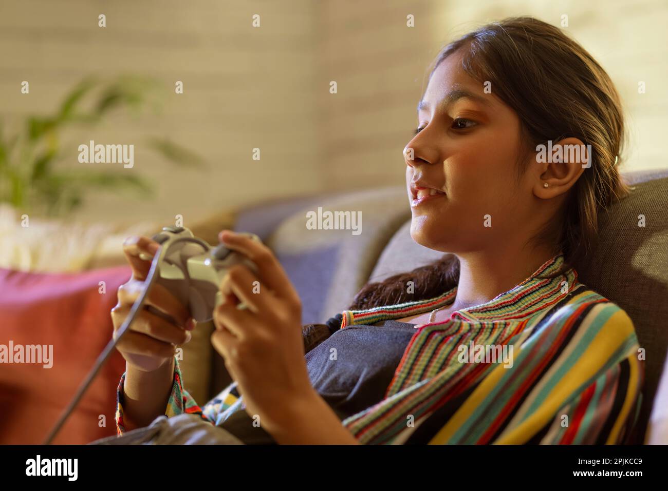 Girl playing video game in living room Stock Photo - Alamy