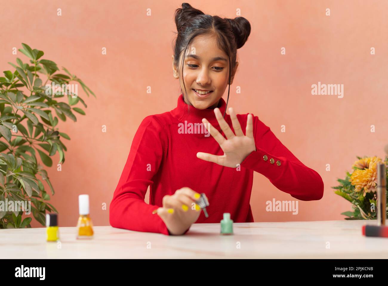 Portrait of a tween girl painting her finger nails Stock Photo - Alamy