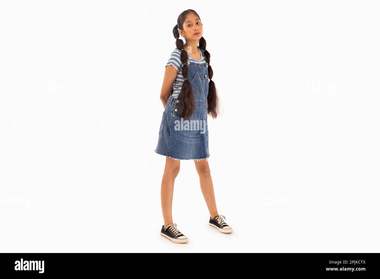 Tween girl with braided hair standing against white background Stock ...