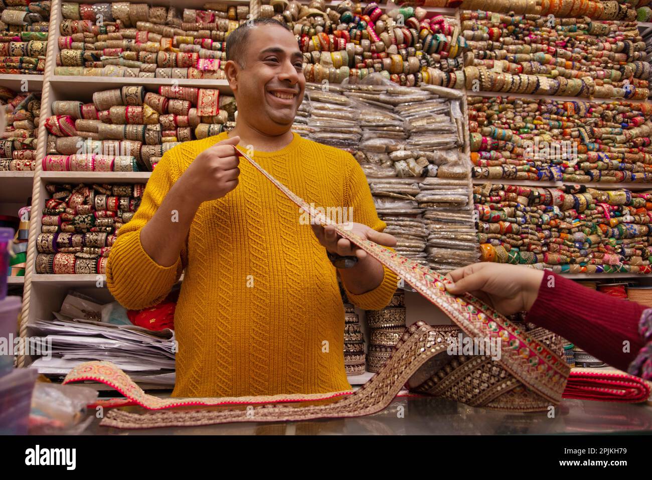 Male fabric vendor showing border and lace to a female buyer Stock ...