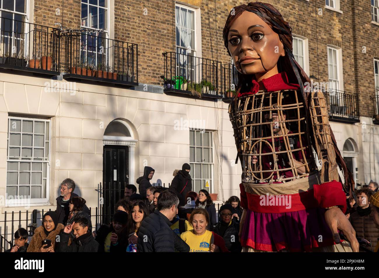 London, UK. 2nd April, 2023. Local residents accompany Little Amal, a ...