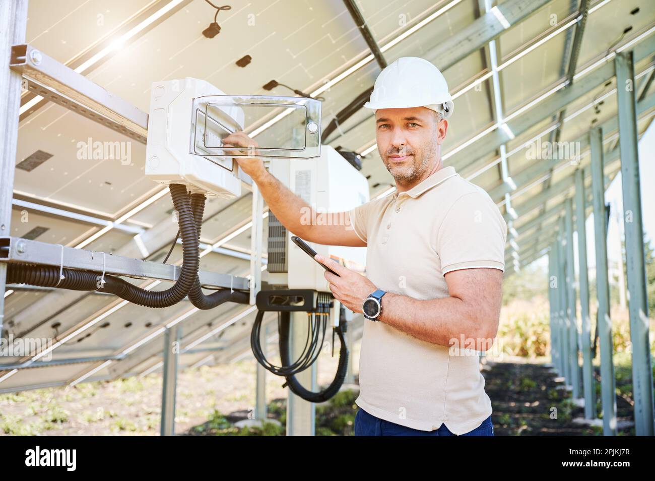 Man adjusting electric switchboard according to instuctions. Male ...