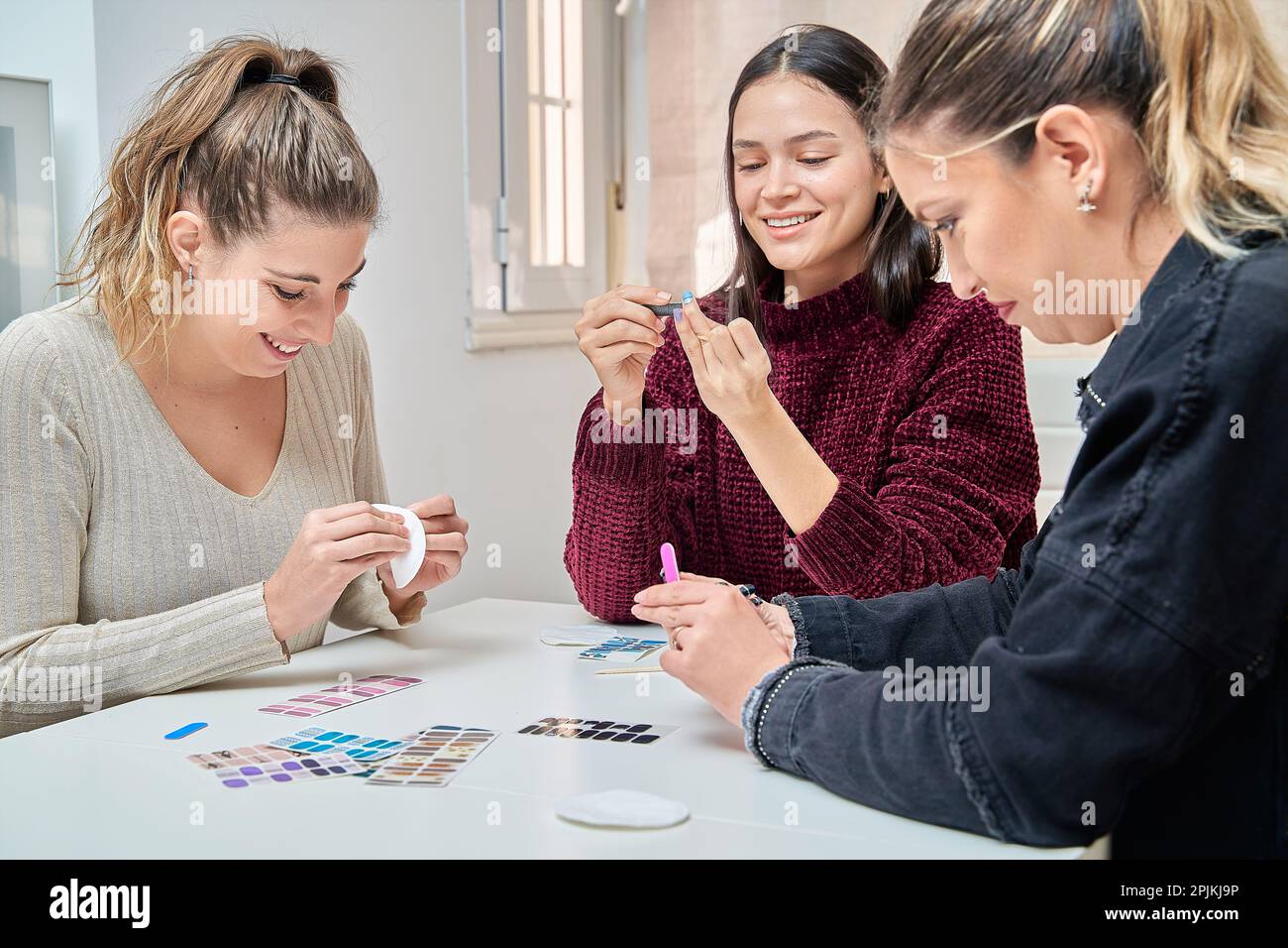 Female friends having fun while doing their nails together. Manicure ...