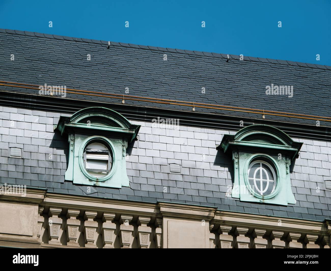 Two round windows of a modern, white Haussmanian building stands tall ...