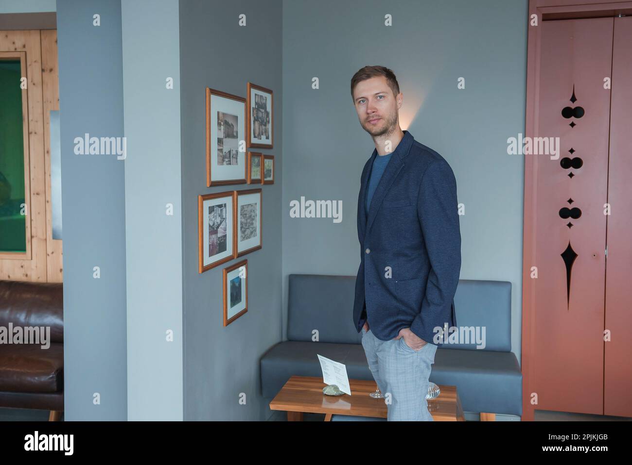 Man with hands in pockets standing by wall at luxury hotel Stock Photo ...