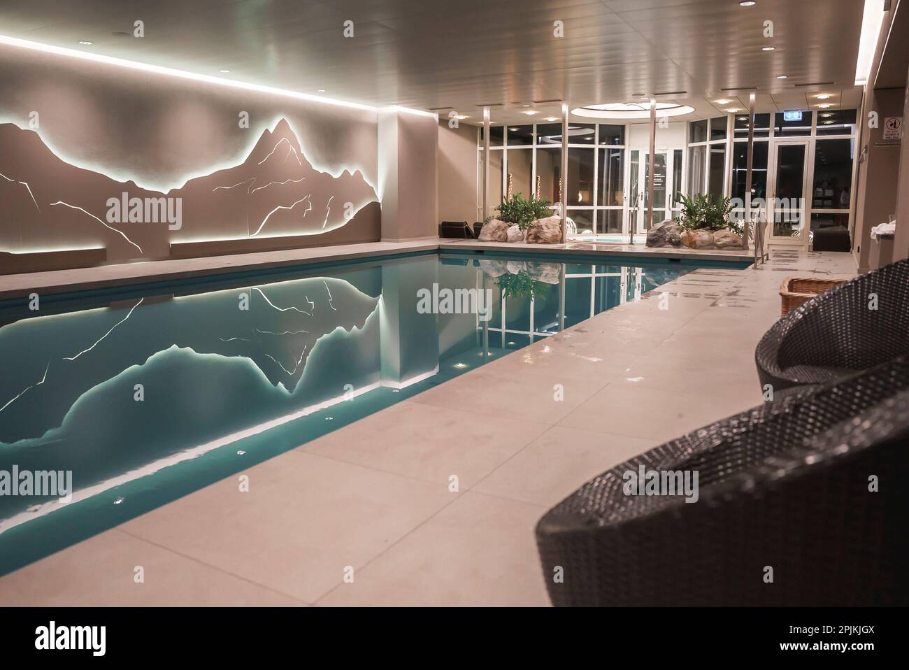 Interior of the illuminated luxury hotel with swimming pool and decor ...