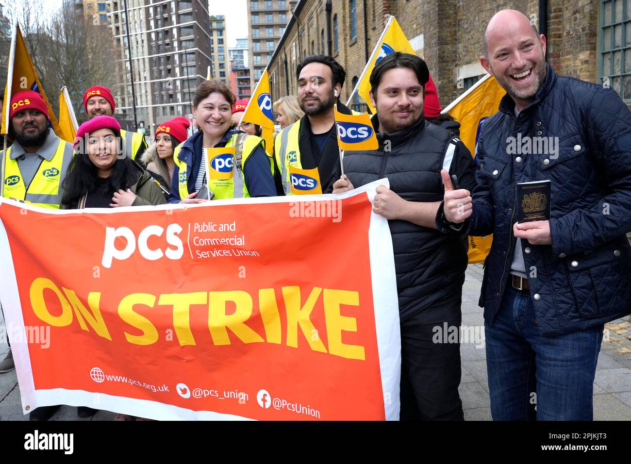 Alex Sladen, right, holds up his new passport alongside Members of the ...