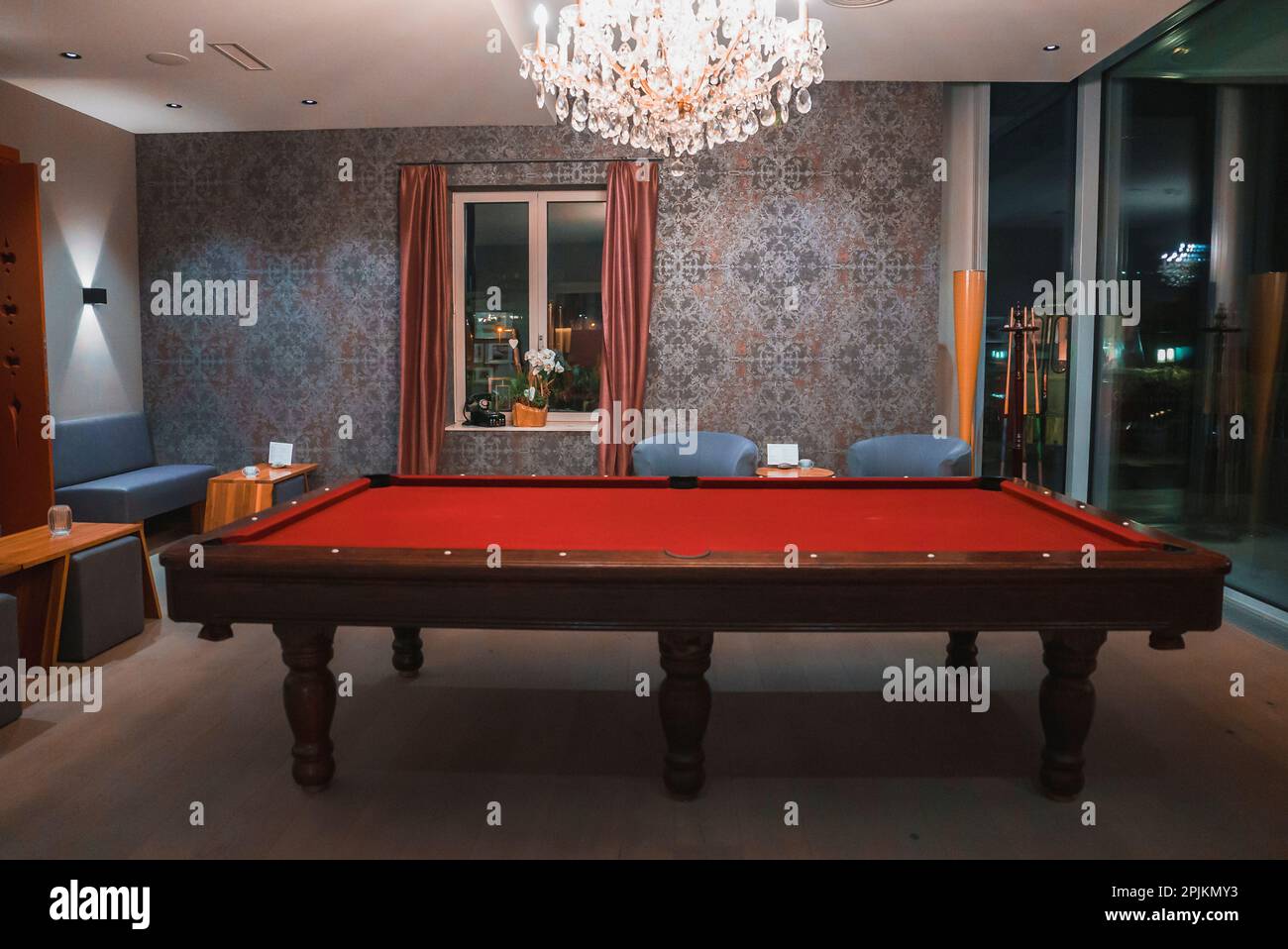 Chandelier over red snooker table in luxury hotel Stock Photo - Alamy