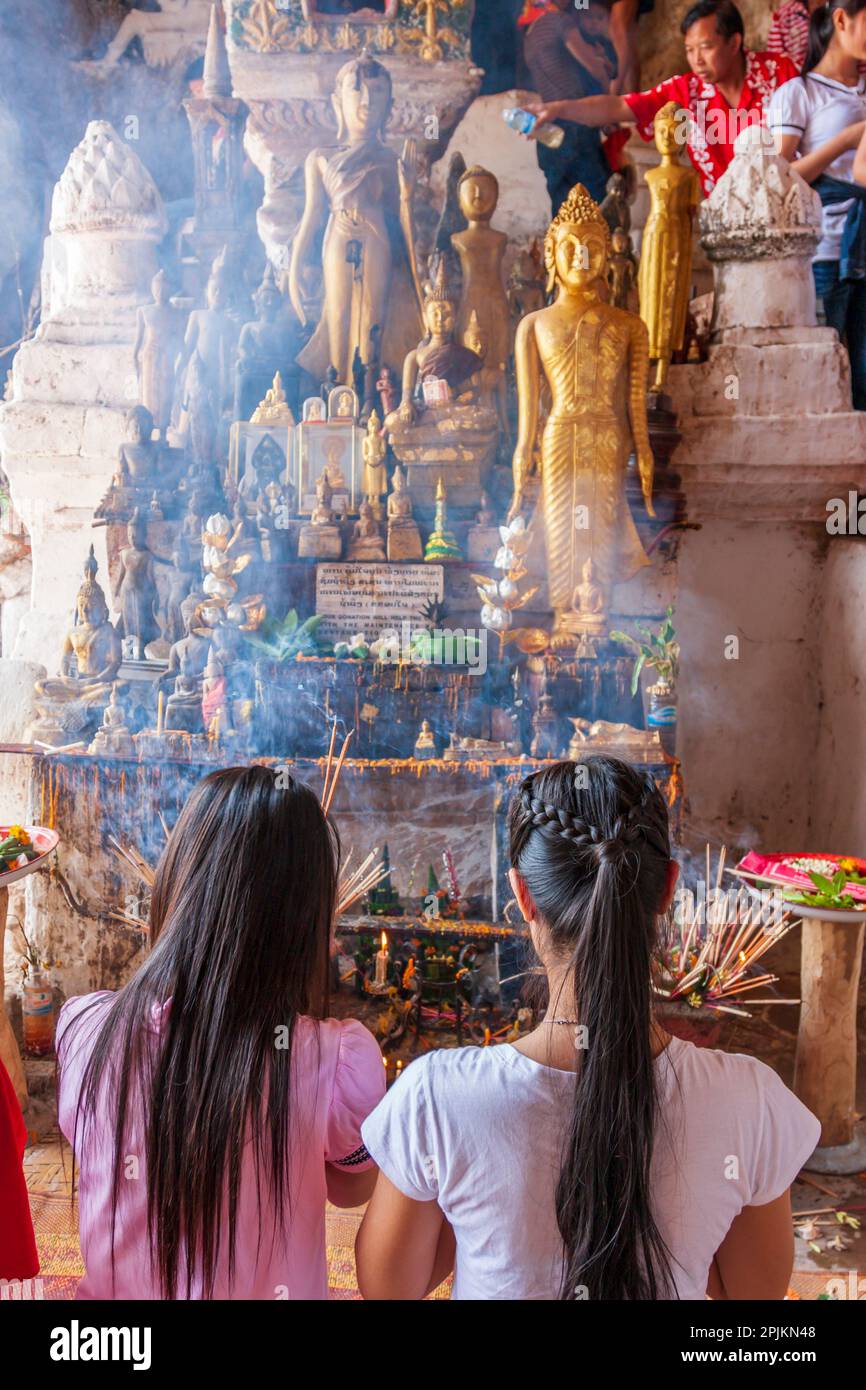 Laos, Luang Prabang. Pak Ou. Tham Ting caves. People praying and ...
