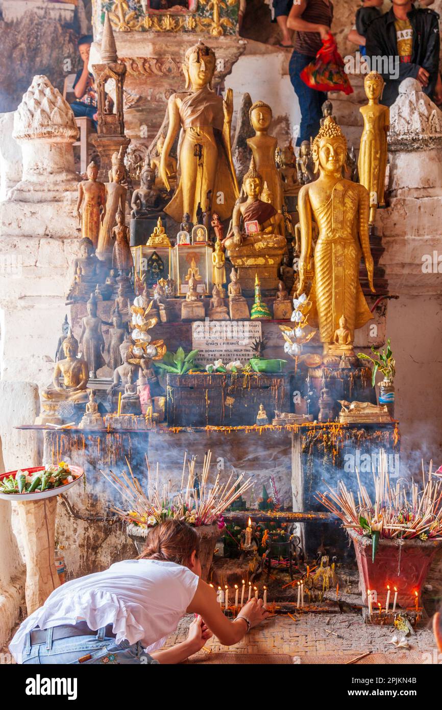 Laos, Luang Prabang. Pak Ou. Tham Ting caves. People praying and ...