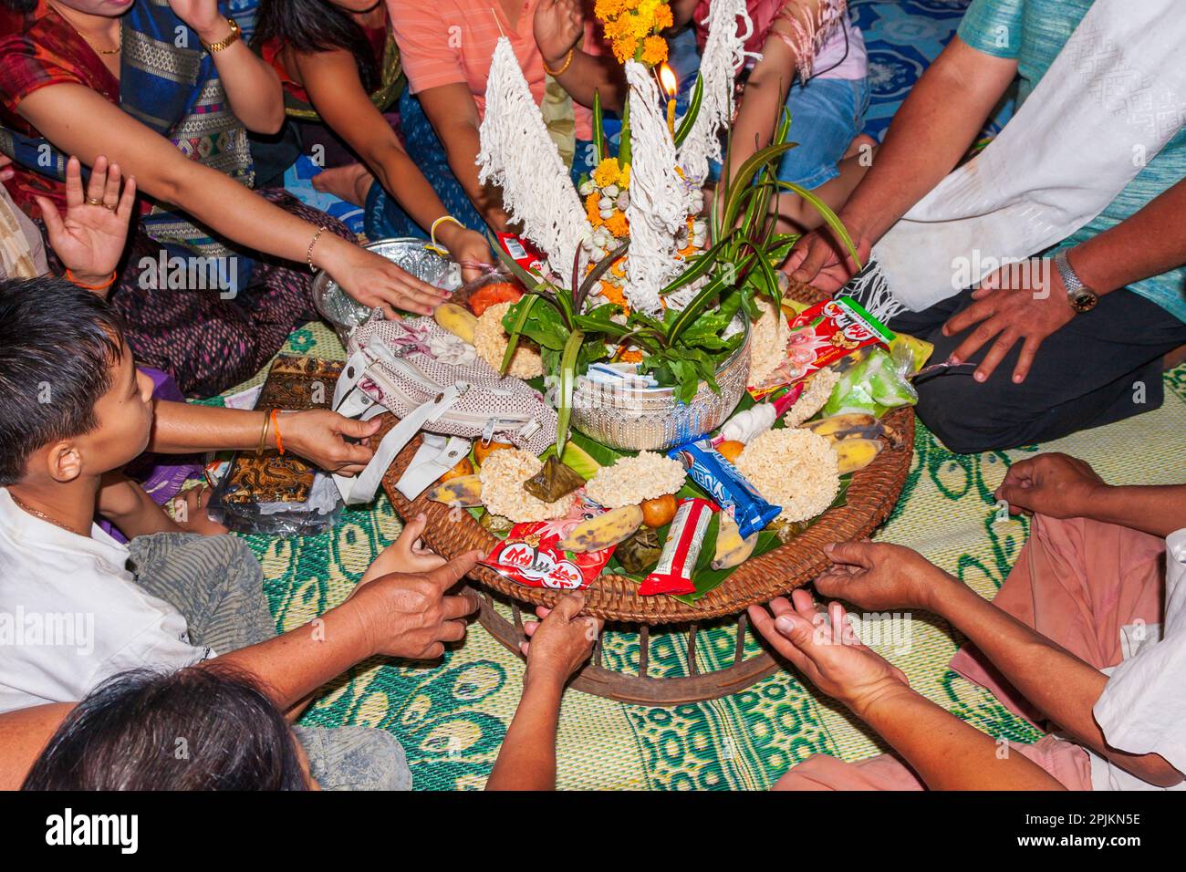 Laos, Luang Prabang. Family around a table, possibly small altar ...