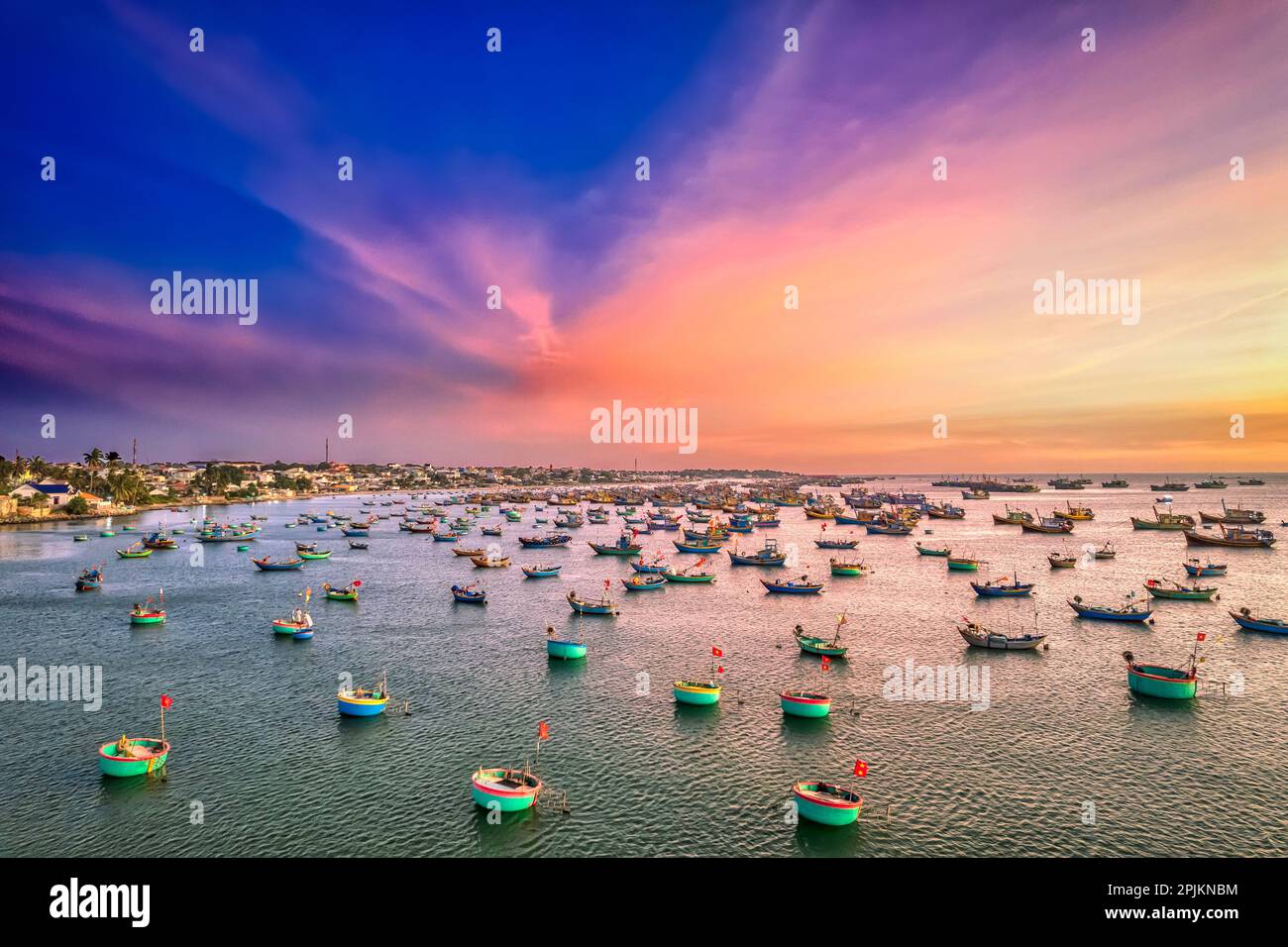 Aerial view of Mui Ne fishing village in sunset sky with hundreds of ...