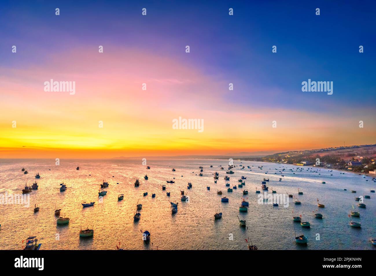 Aerial view of Mui Ne fishing village in sunset sky with hundreds of ...