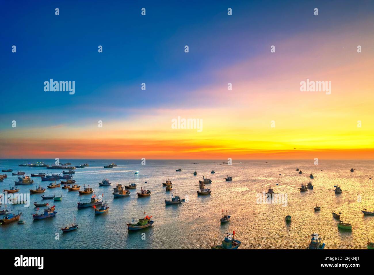 Aerial view of Mui Ne fishing village in sunset sky with hundreds of ...