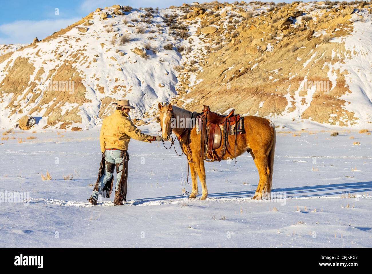 USA, Wyoming. Hideout Horse Ranch, wrangler and horse in snow. (MR,PR ...