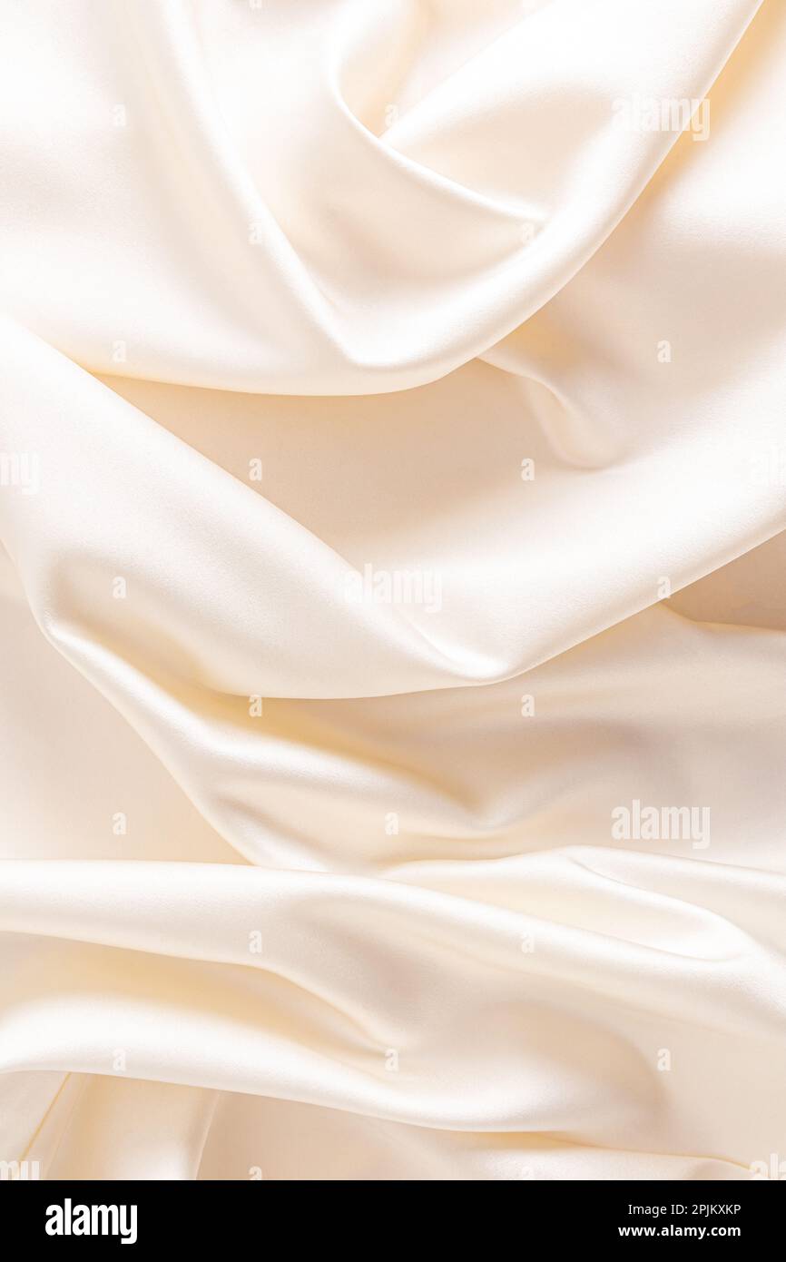 Delicate waves of satin fabric of beige color. vertical view. wedding ...