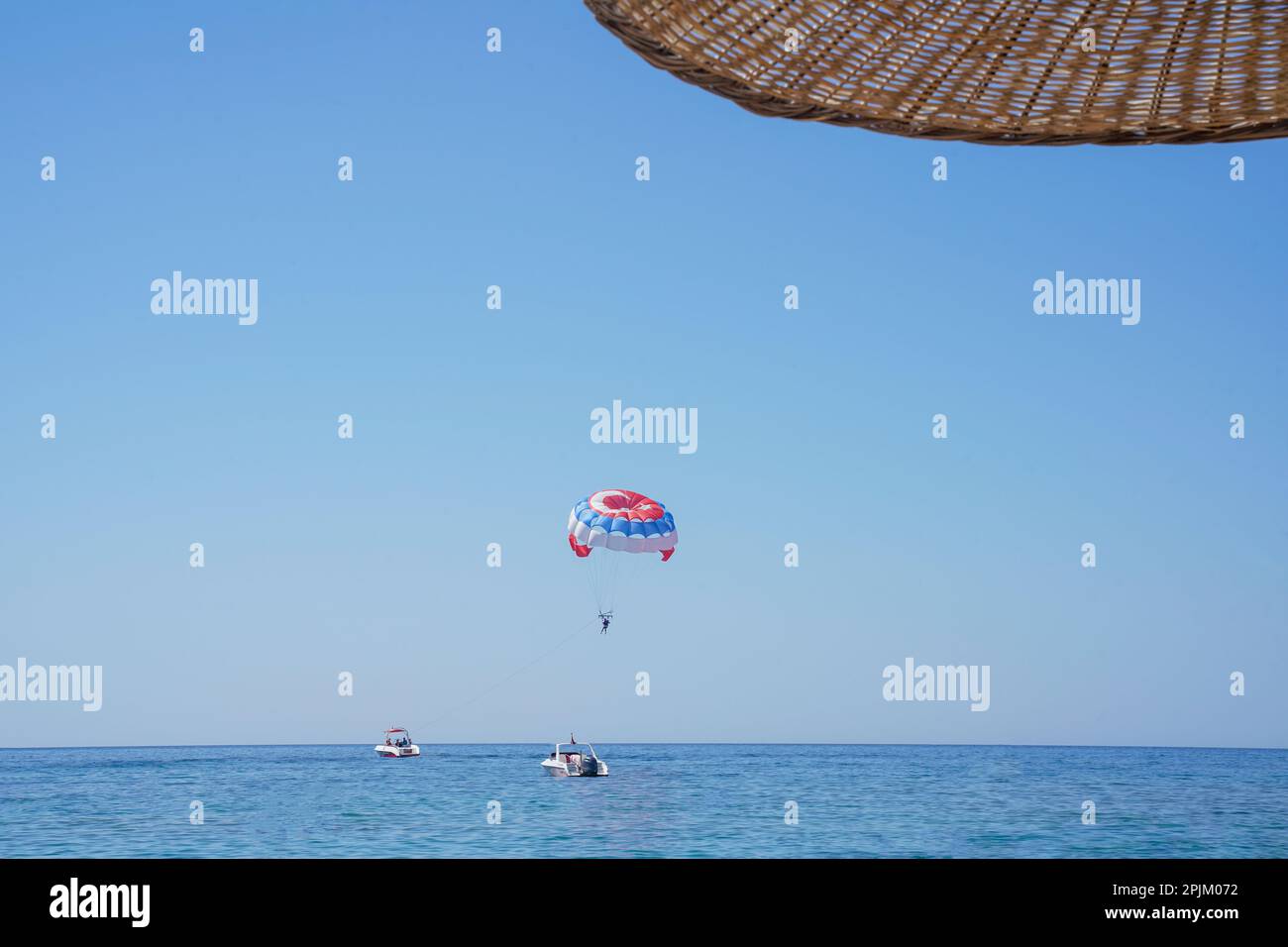 Parasailing on a parachute against the blue sky. Background vacation ...