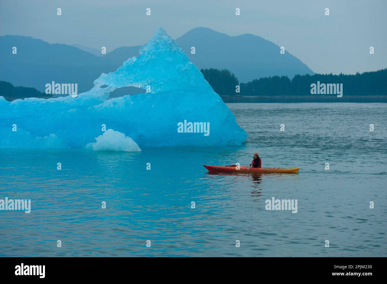 A kayaker paddling near icebergs at the mouth of Tracy Arm. (Editorial ...