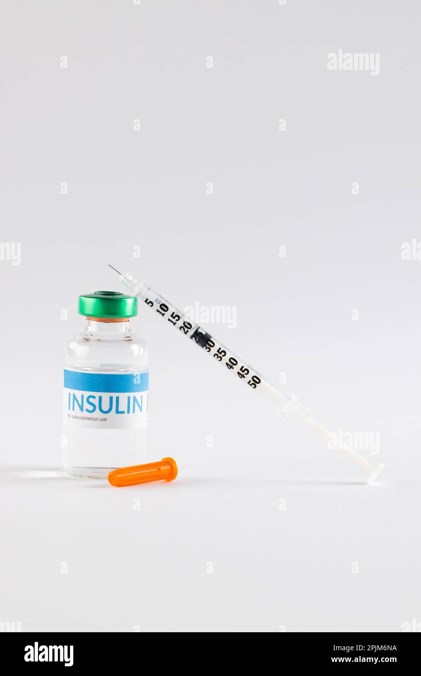 Insulin vial and uncapped syringe on white background with copy space ...