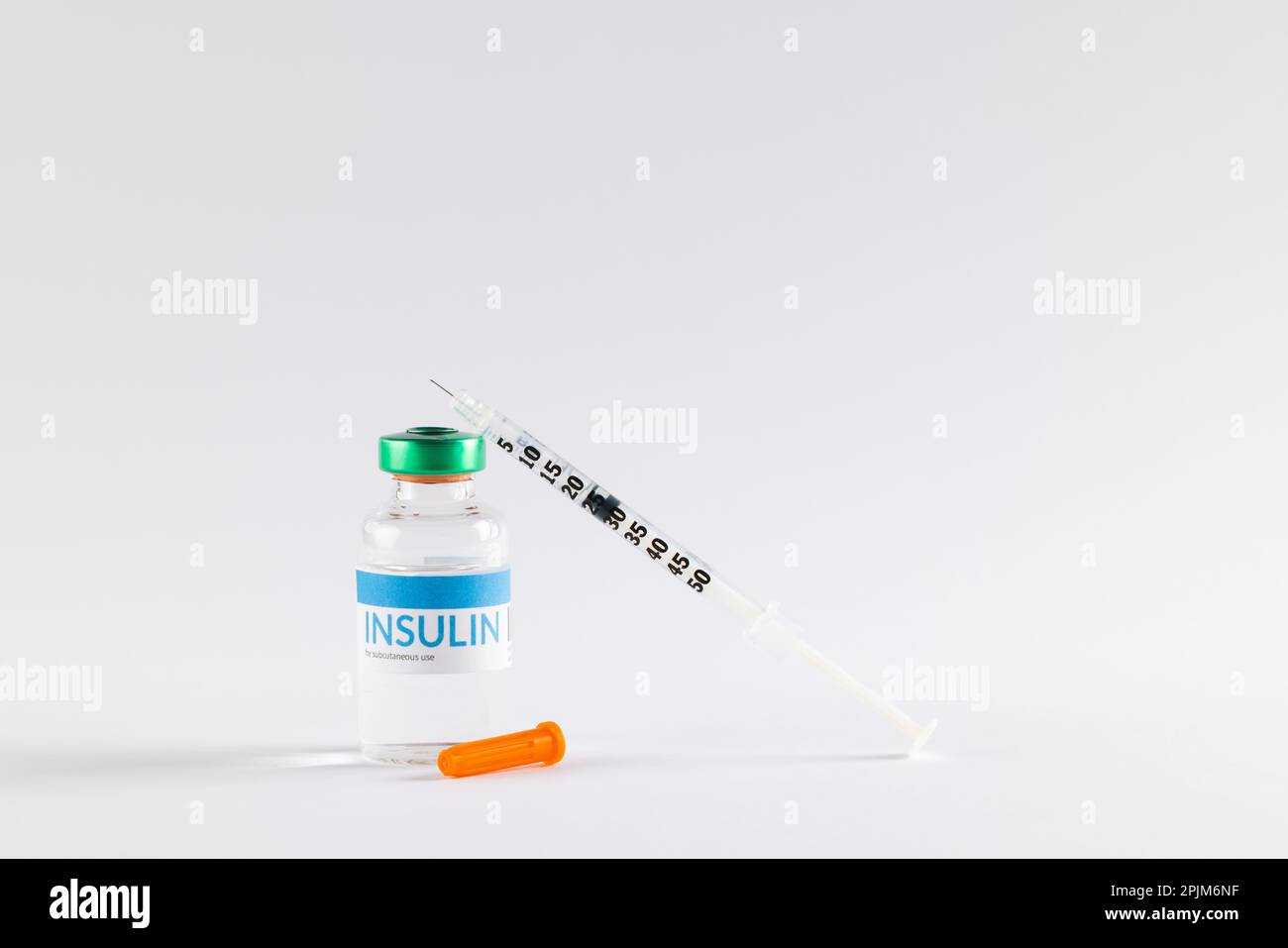 Insulin in vial and uncapped syringe on white background with copy ...