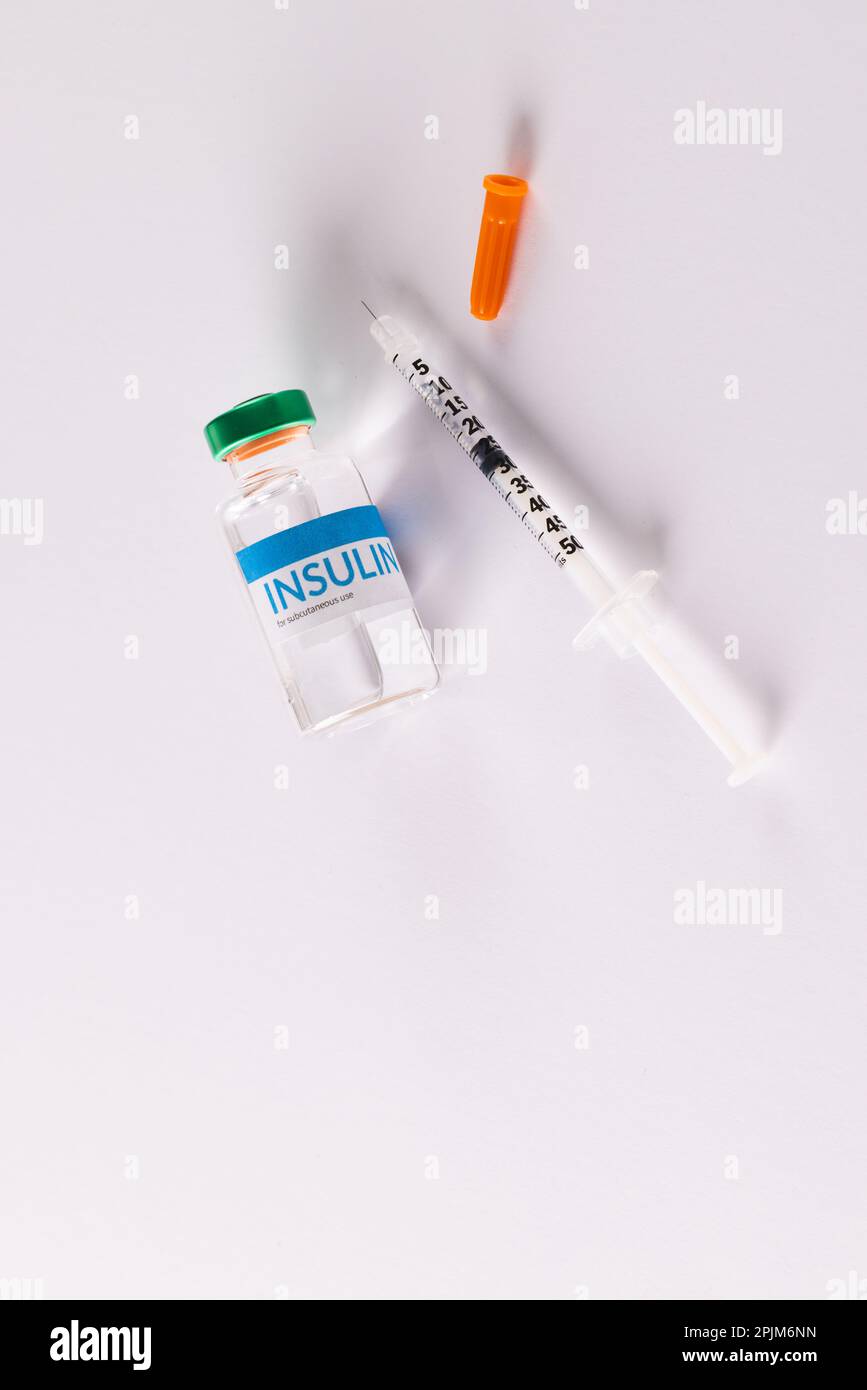 Insulin vial and uncapped syringe on white background with copy space ...