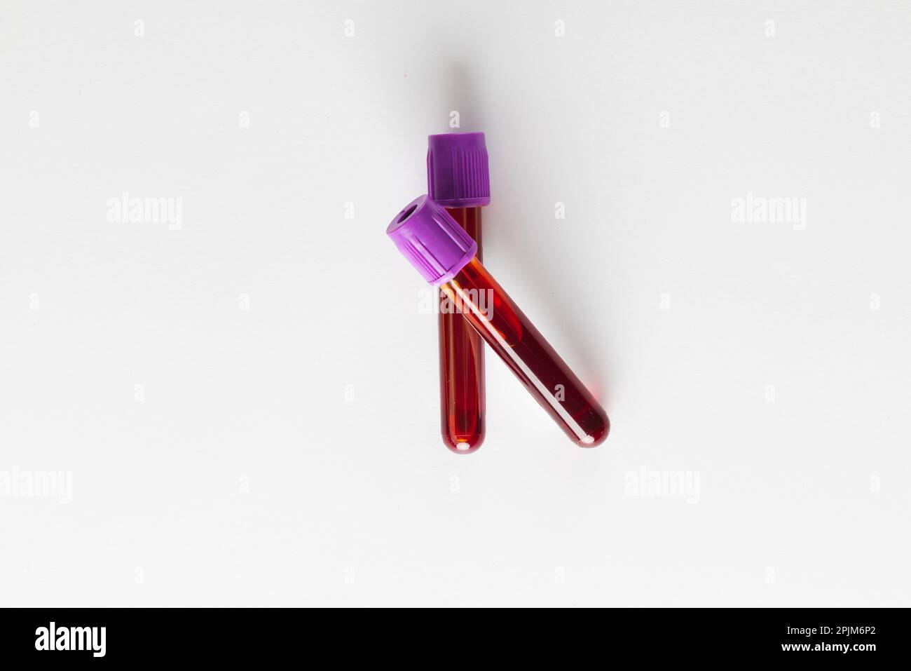 Two blood sample tubes with purple lids, on white background Stock Photo - Alamy