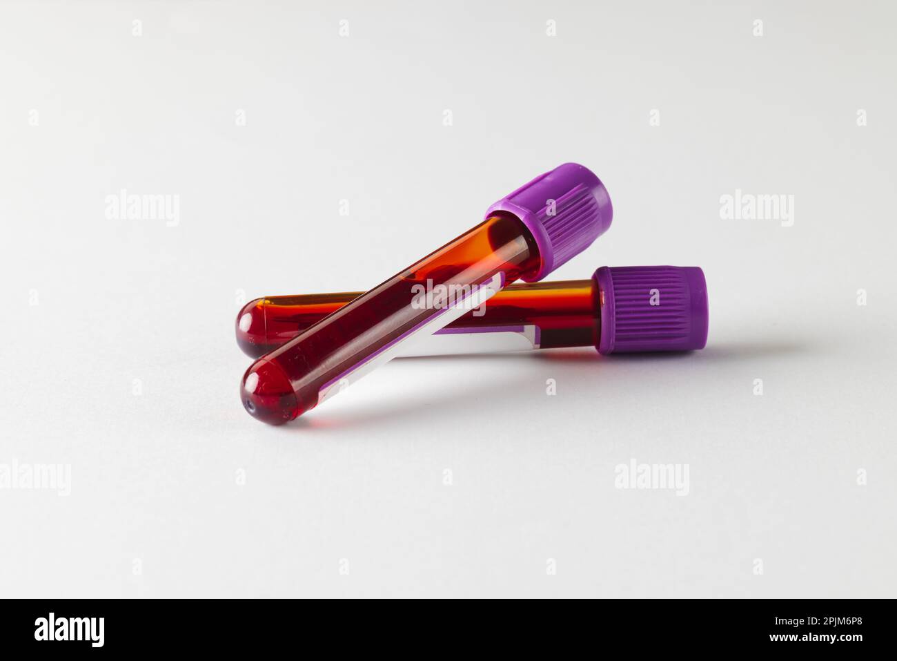 Two blood sample tubes with purple lids, on white background Stock ...