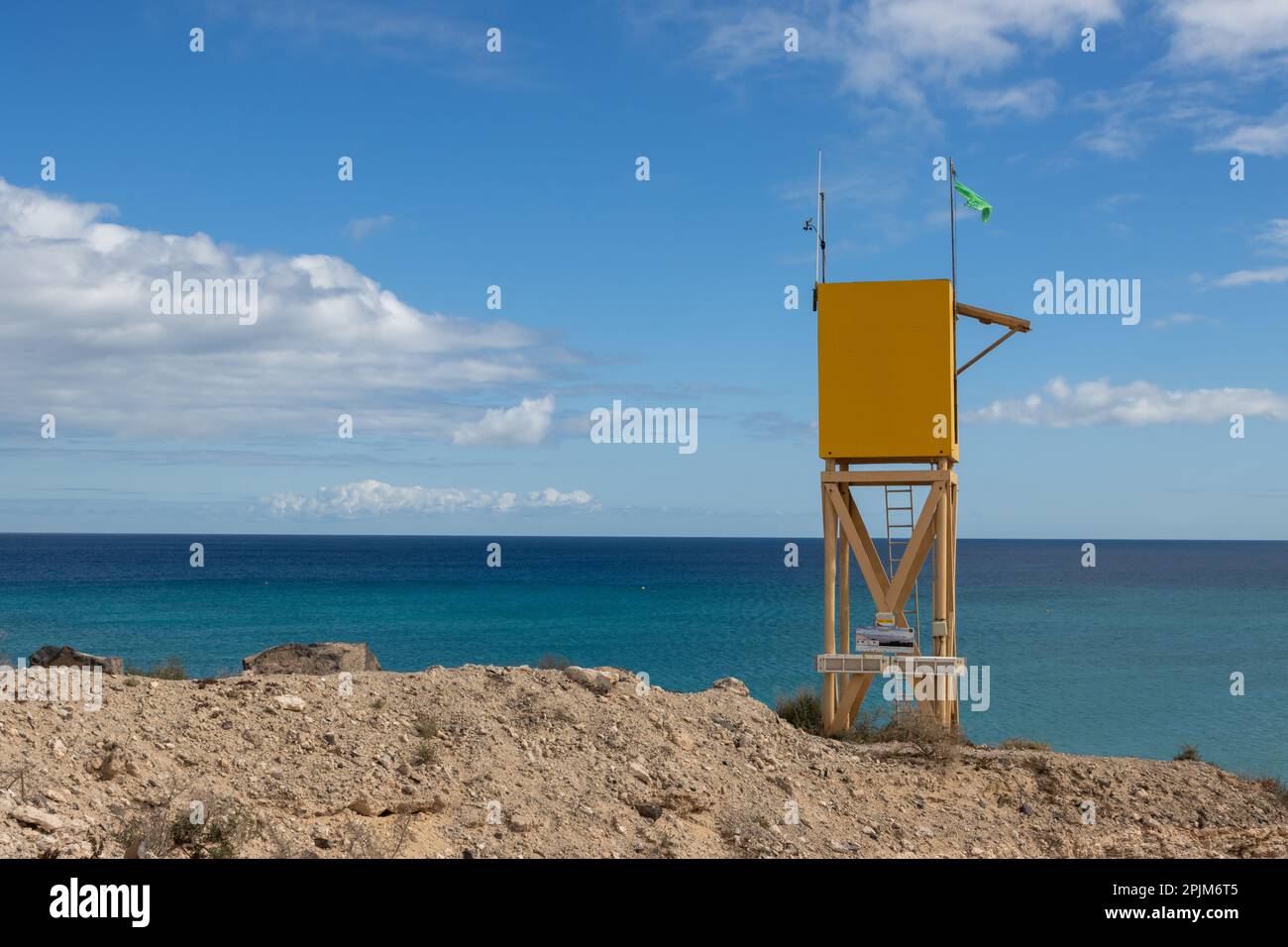 Sand soil and lifeguard yellow tower above the beach. Calm turquoise ...