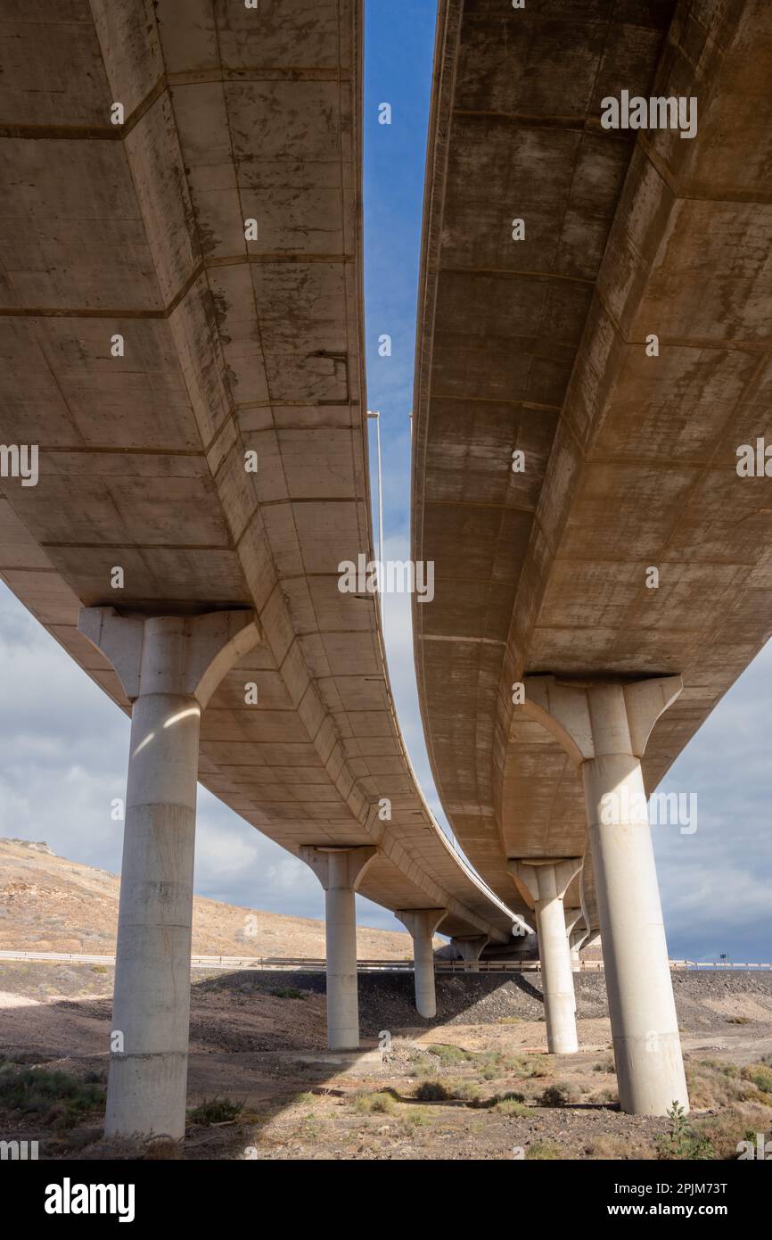 View from down on the pilars and highway bridge. Blue sky with white ...