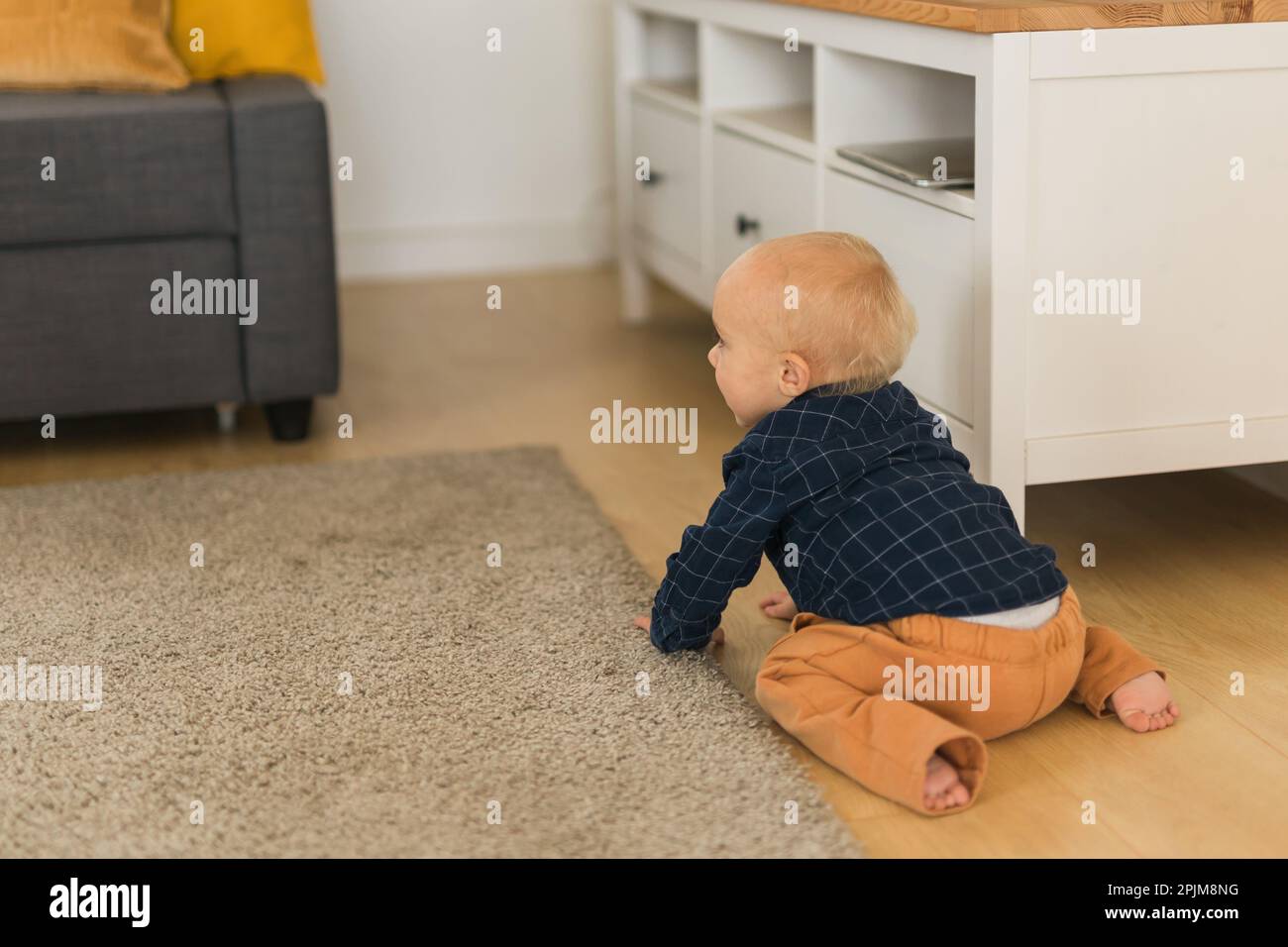 Nursery baby boy crawling on floor indoors at home copy space and empty ...