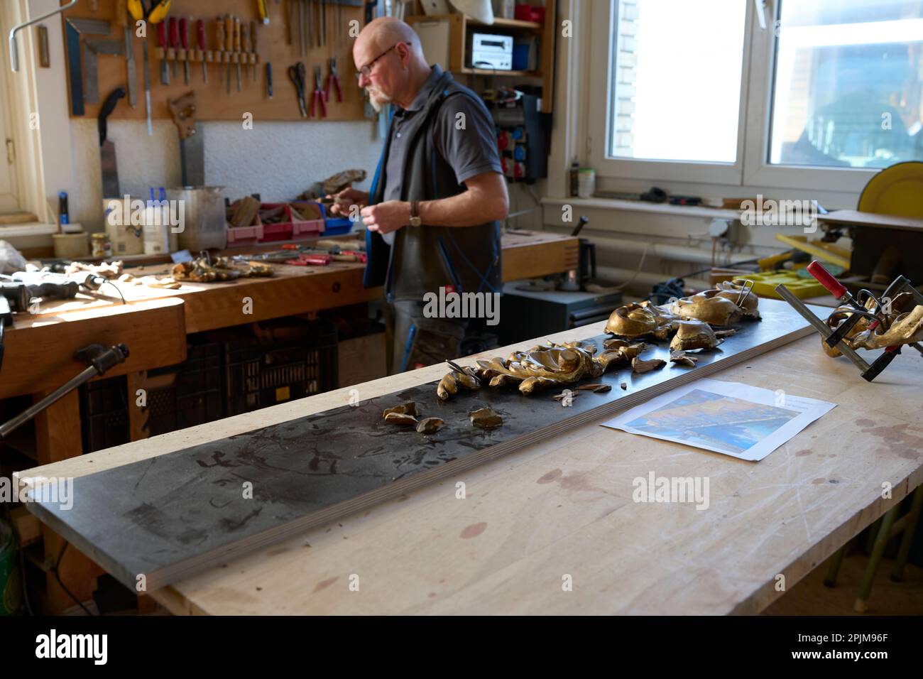 A skilled craftsman is carefully chiseling a piece of wood, creating a ...