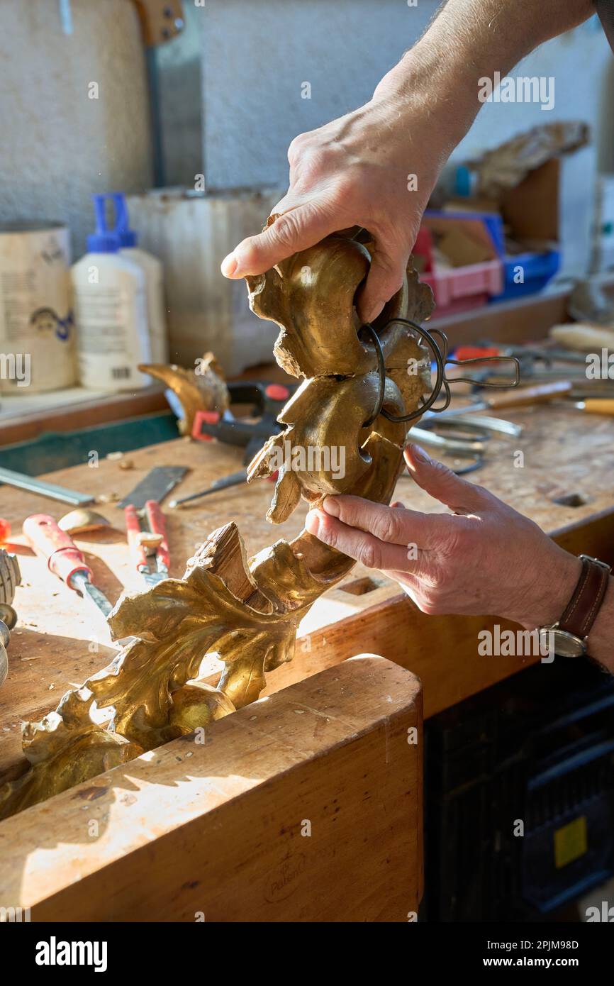 A skilled craftsman is carefully chiseling a piece of wood, creating a ...