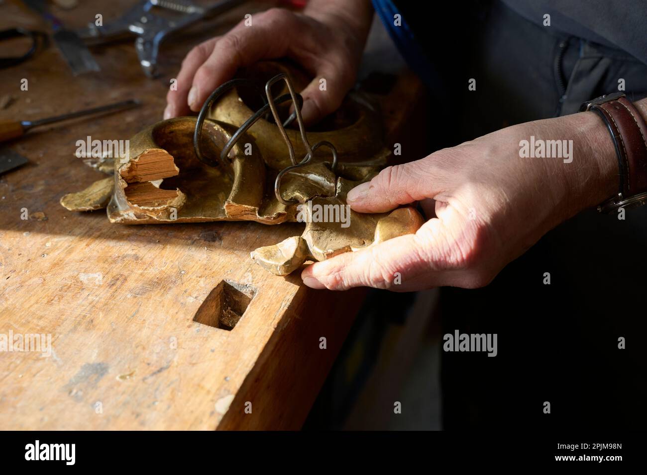 A skilled craftsman is carefully chiseling a piece of wood, creating a ...
