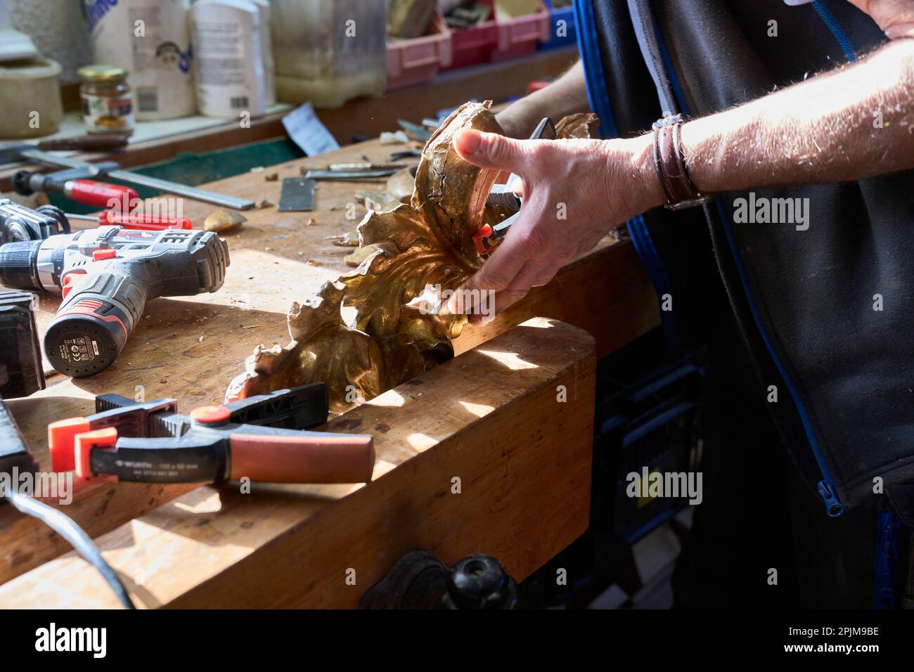 A skilled craftsman is carefully chiseling a piece of wood, creating a ...