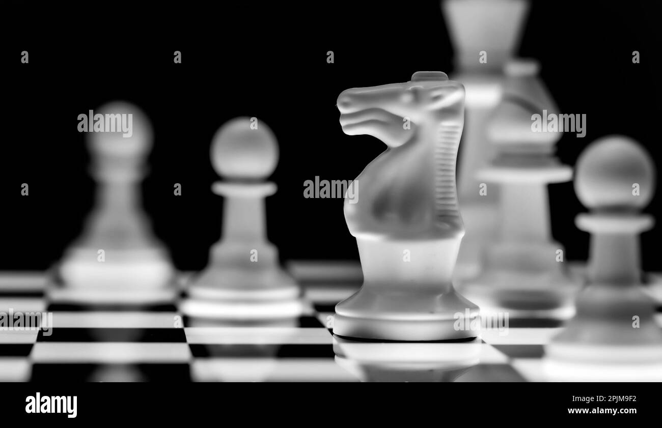 Close up of Chess pieces on a reflective mirror board surface with a ...