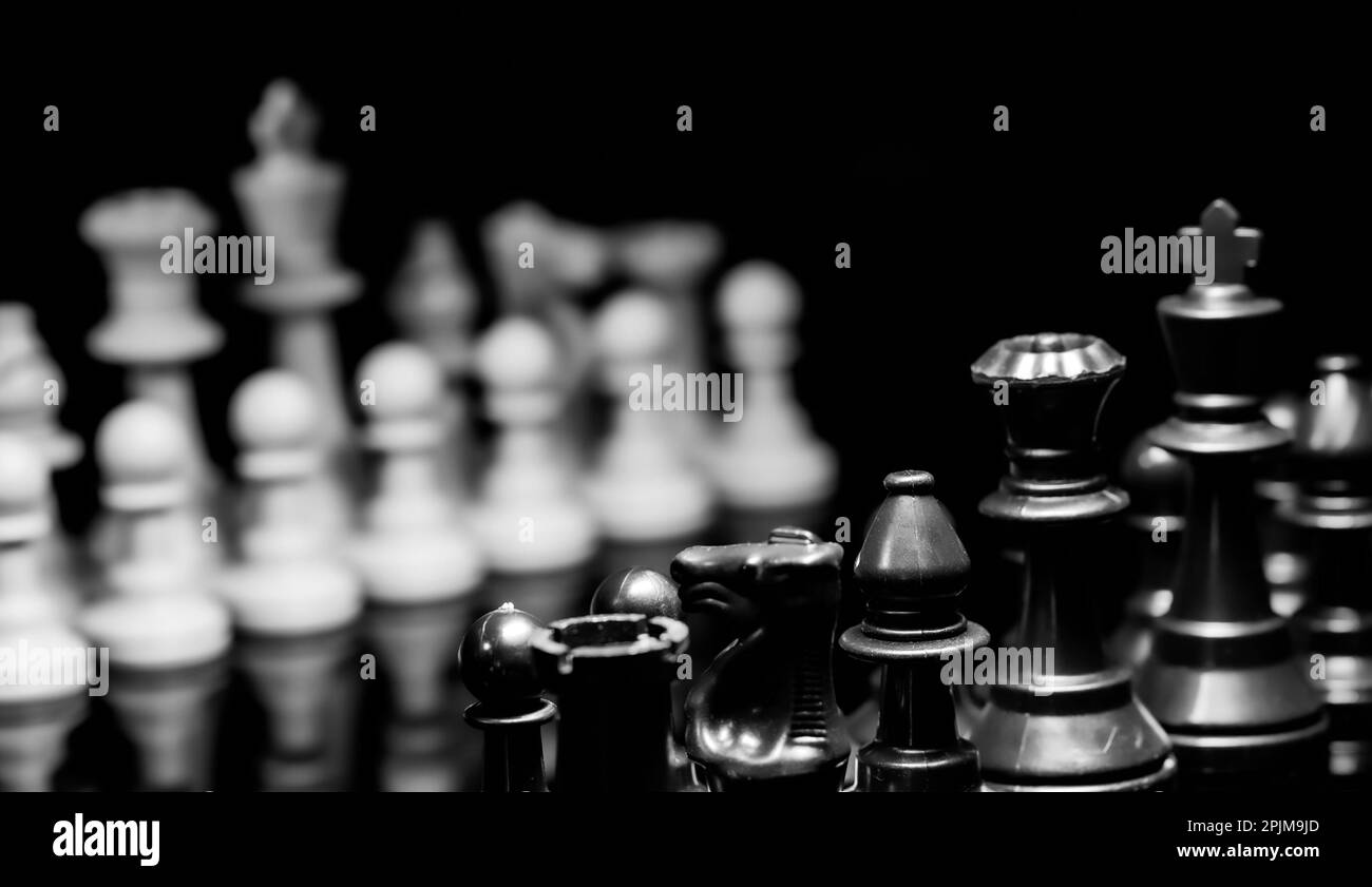 Close up of Chess pieces on a reflective mirror board surface with a ...