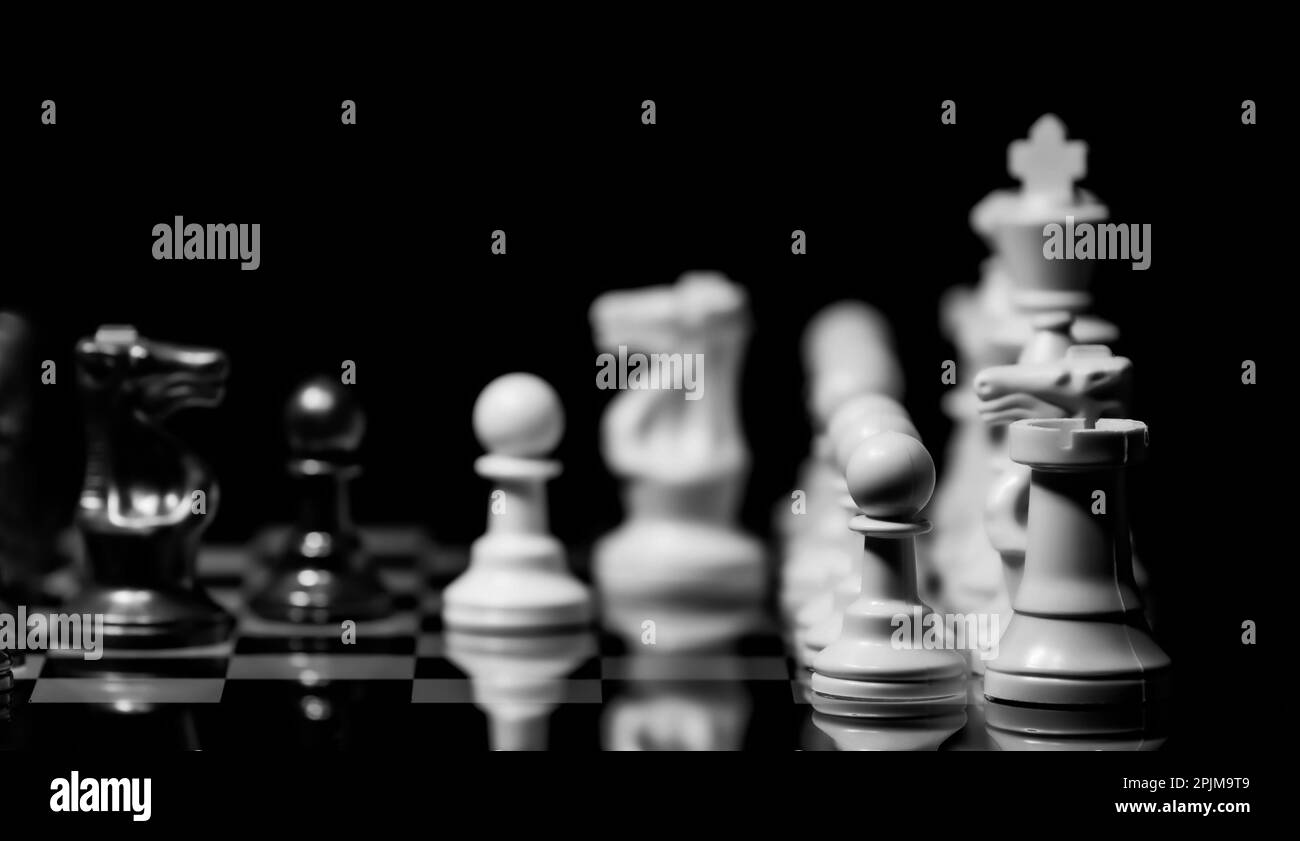 Close up of Chess pieces on a reflective mirror board surface with a ...