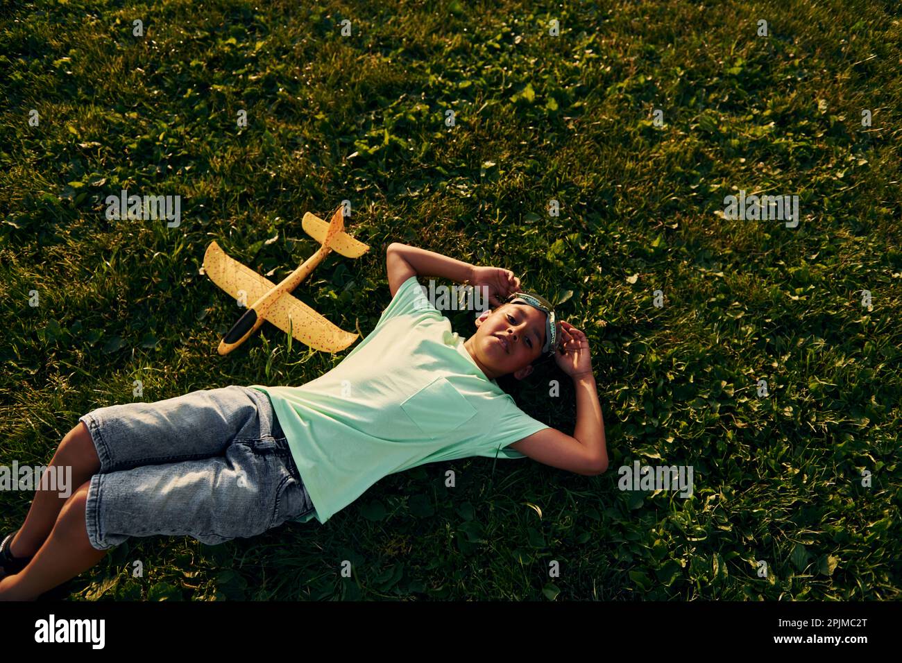 Resting on the ground. African american kid have fun in the field at ...