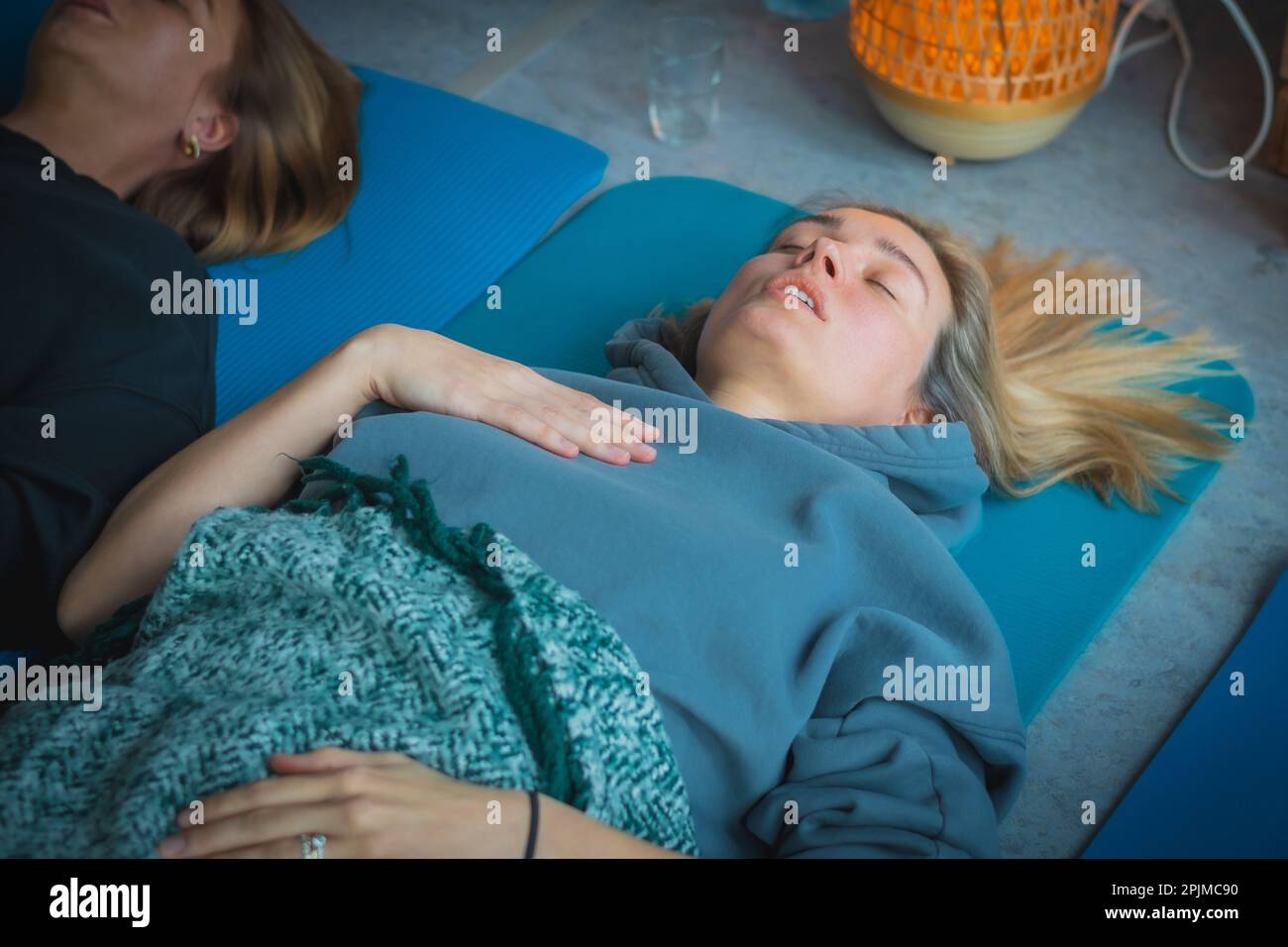 Beautiful Caucasian blond hair girl with a blue sweatshirt lying on a ...