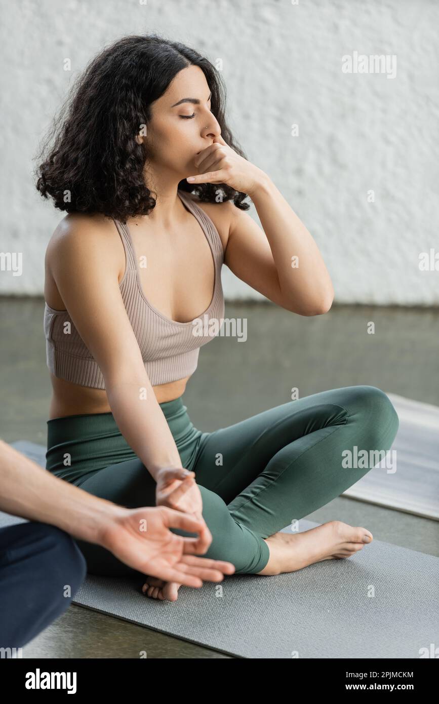 Middle eastern woman in sportswear practicing gyan mudra and nostril ...