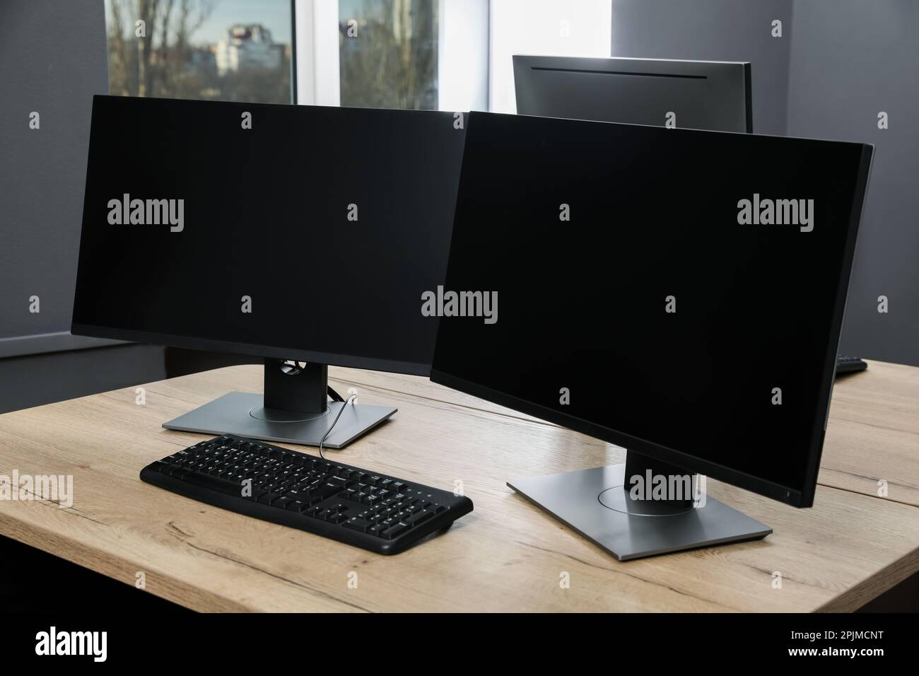 Modern interior. Workplace with multi-monitor on wooden desk in office ...