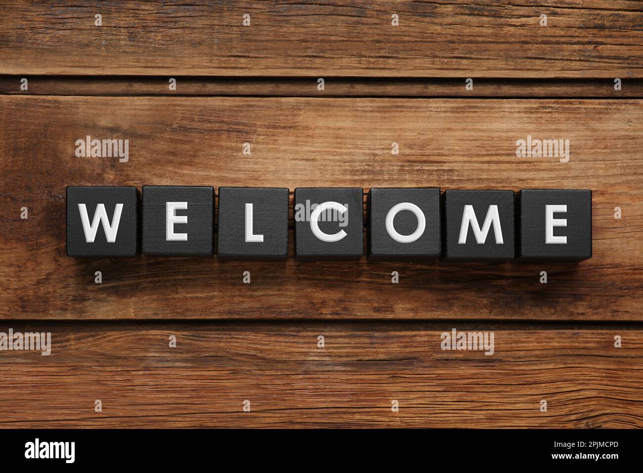 Word Welcome made of black cubes on wooden background, top view Stock ...