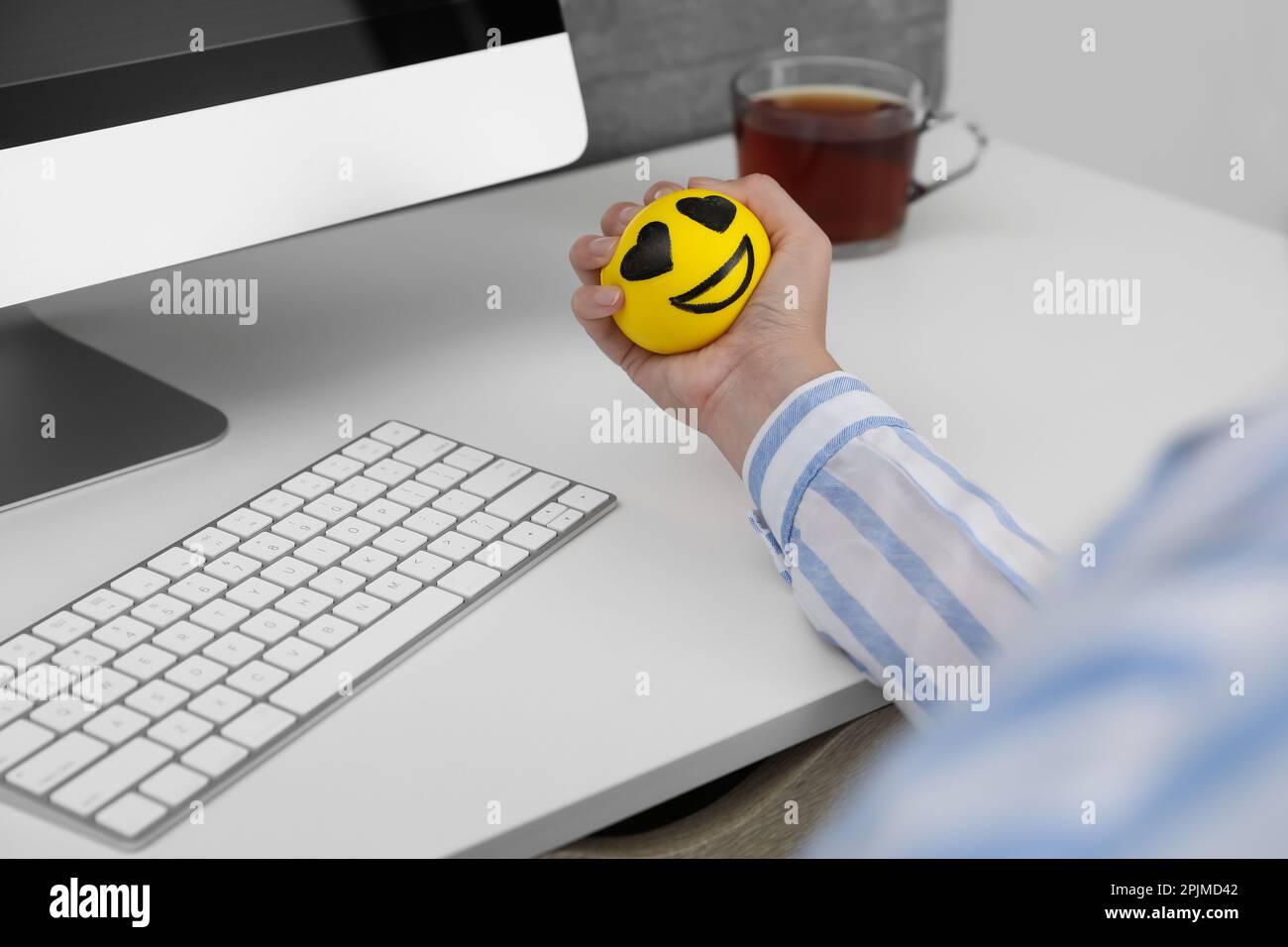Woman squeezing antistress ball at workplace, closeup Stock Photo - Alamy