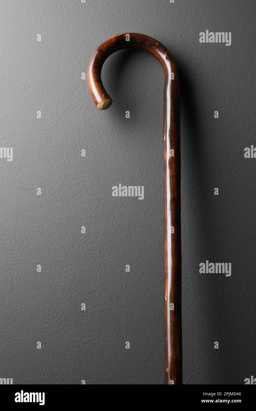 Elegant wooden walking cane on grey background Stock Photo - Alamy