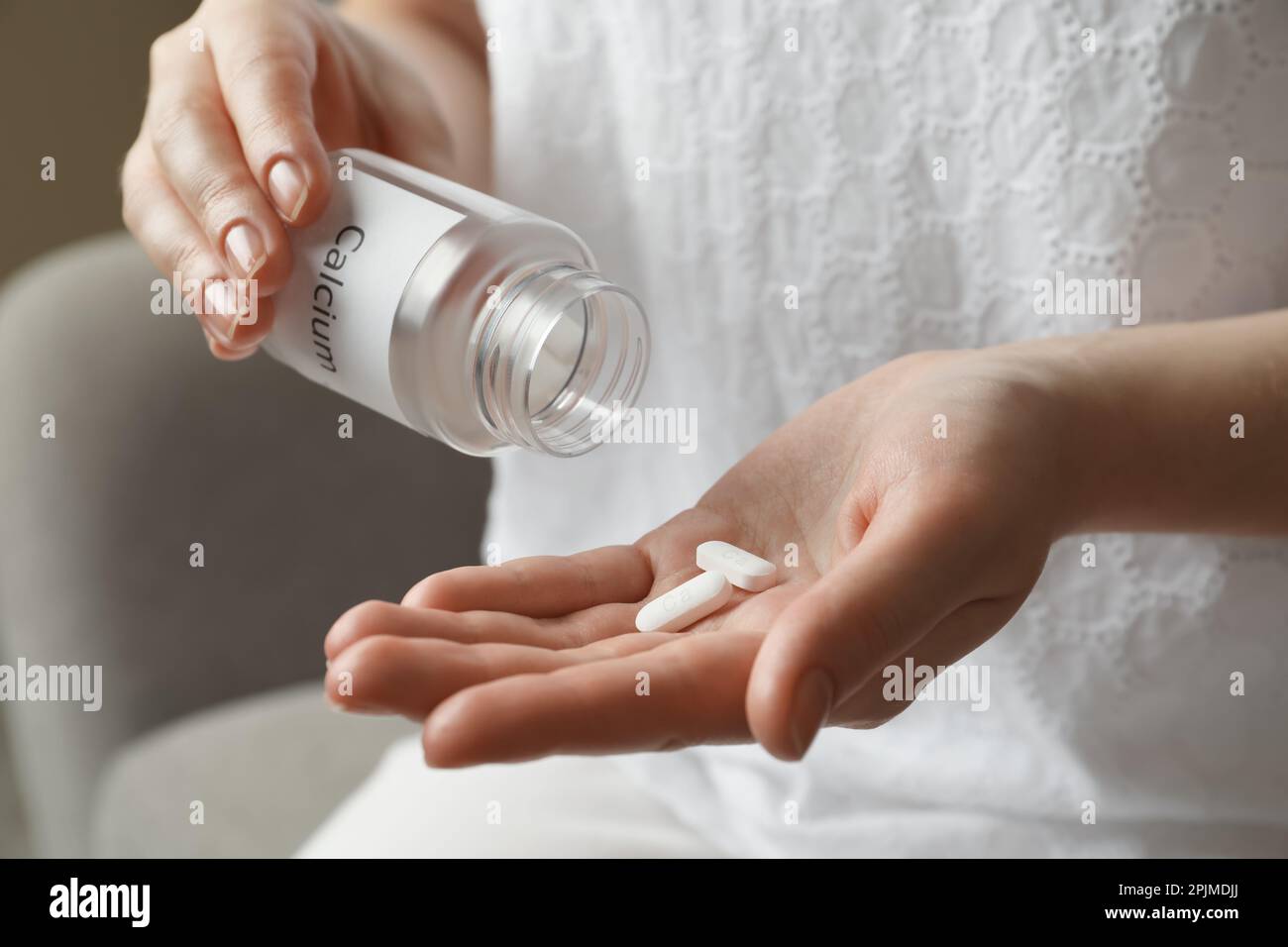 Calcium supplement. Woman taking pills indoors, closeup Stock Photo - Alamy