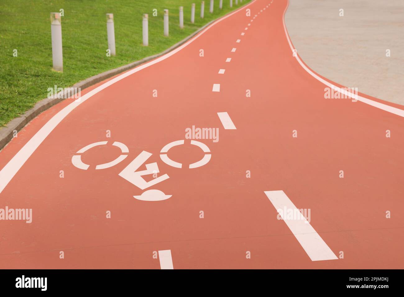 Red bike lane with painted white bicycle sign Stock Photo - Alamy