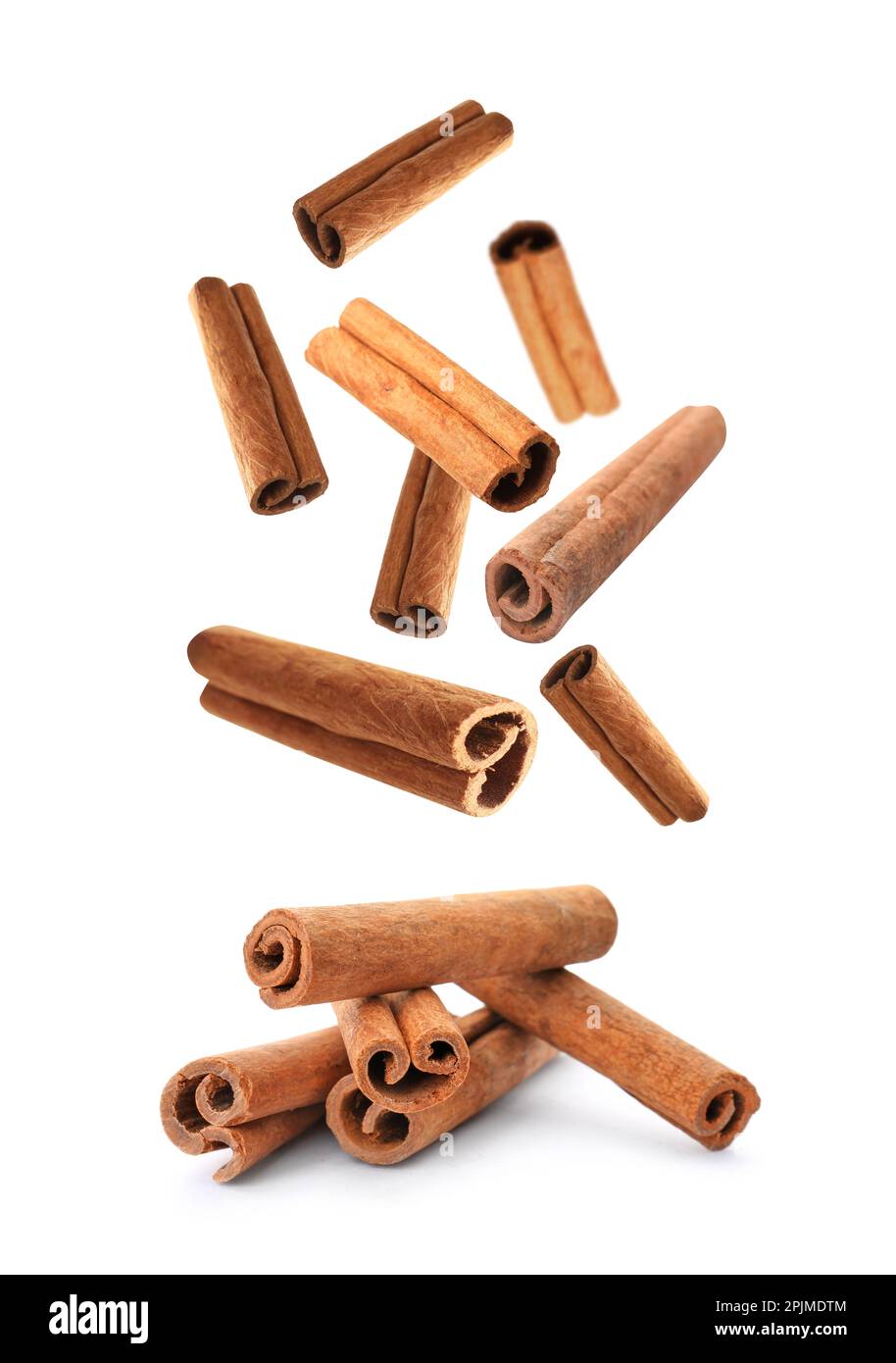 Aromatic cinnamon sticks falling on white background Stock Photo - Alamy