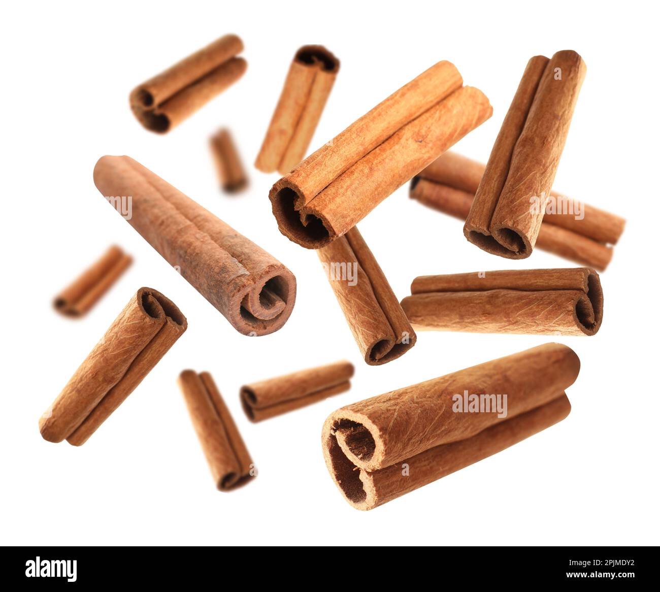 Aromatic cinnamon sticks falling on white background Stock Photo - Alamy