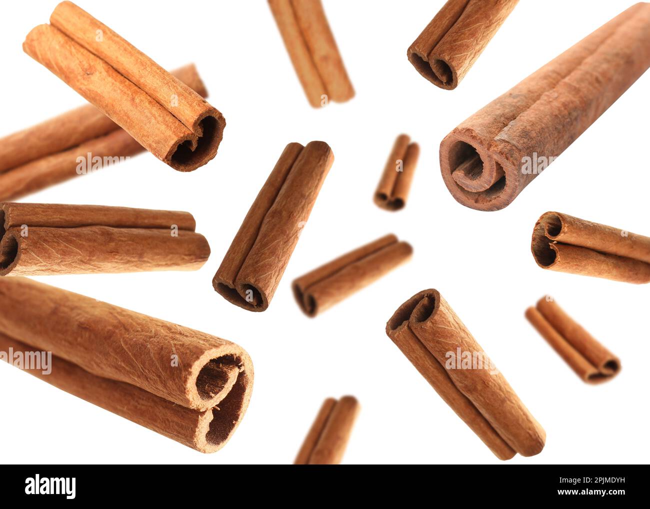 Aromatic cinnamon sticks falling on white background Stock Photo - Alamy